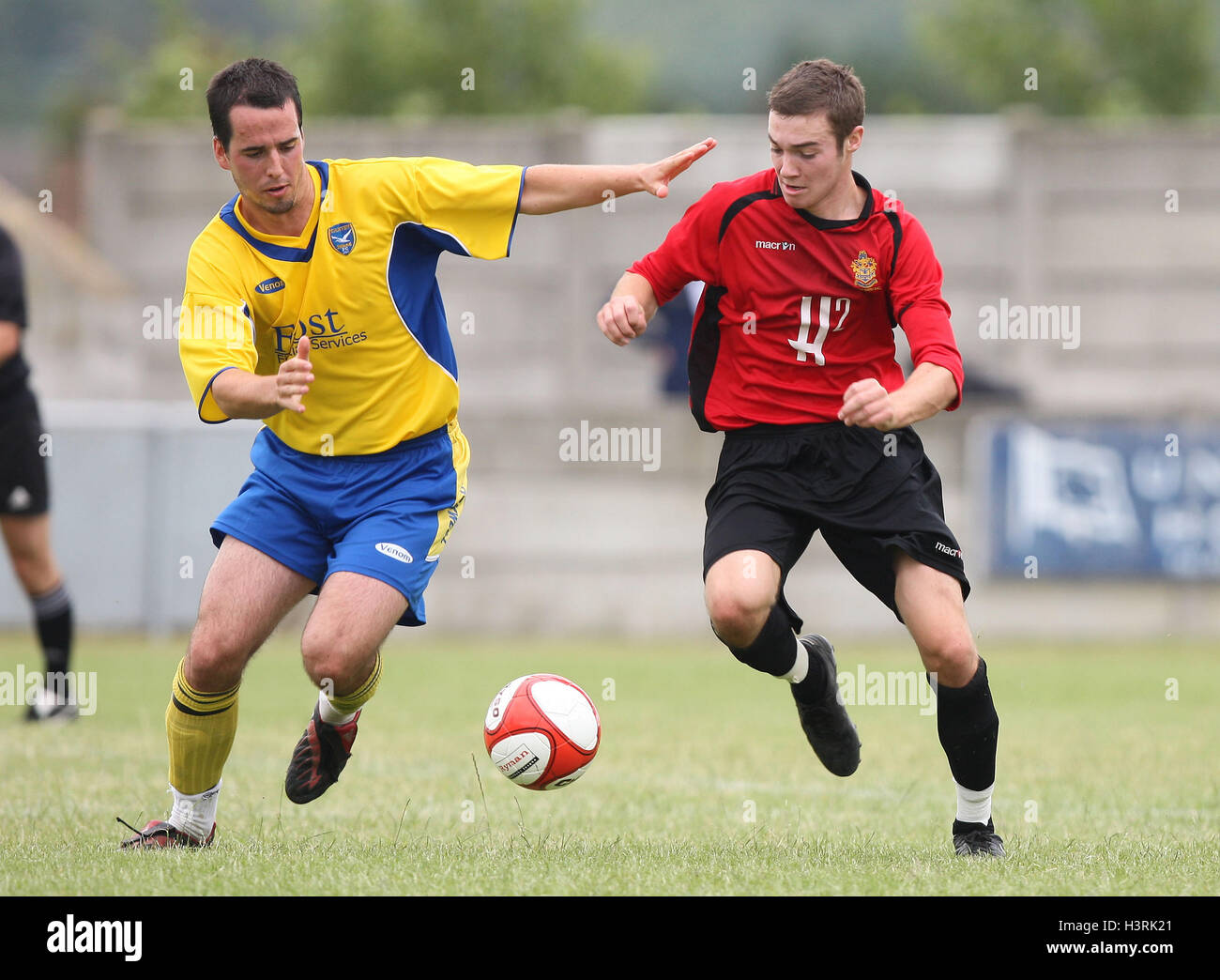 Ben Patten of Canvey (L) gets to grips with Reece Cossom of Romford ...