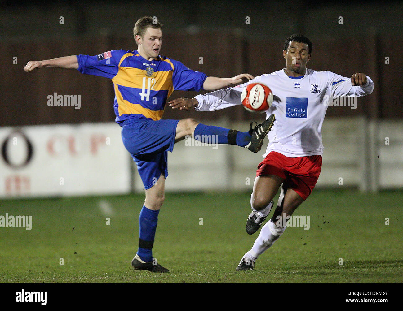 Jack Barry of Romford clears from Adam Wallace of Enfield Town ...