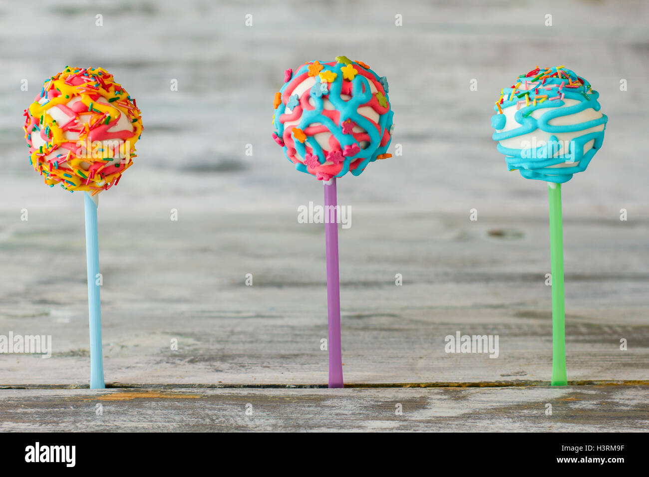 Three cake pops with icing Stock Photo - Alamy