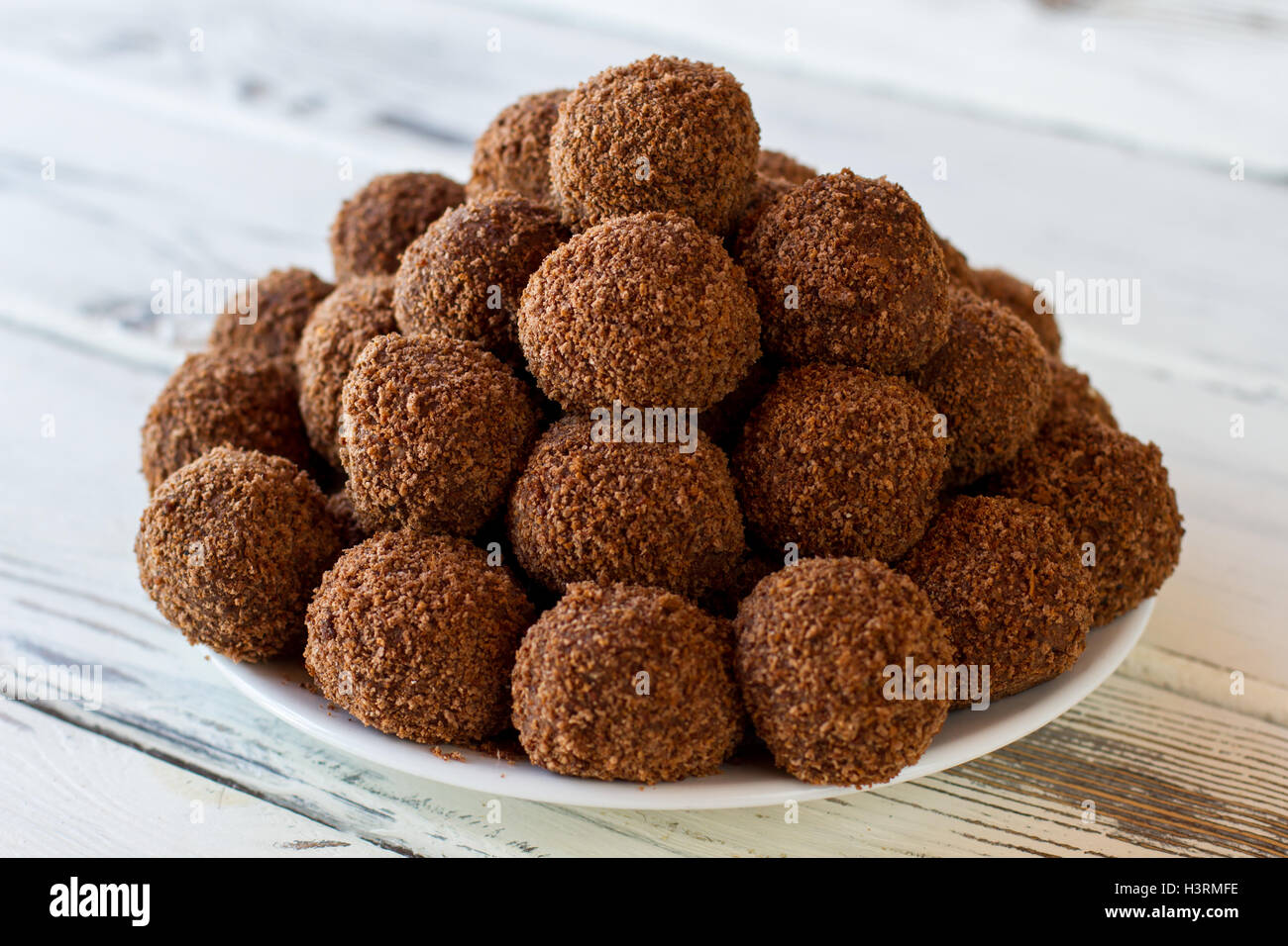 White plate with brown candies Stock Photo - Alamy