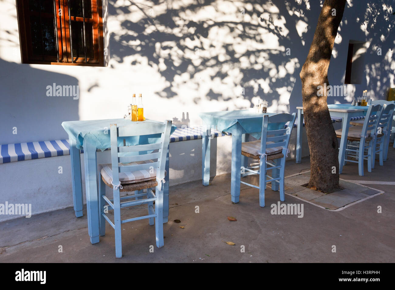 Restaurant tables under a tree with small bottles of olive oil Stock ...