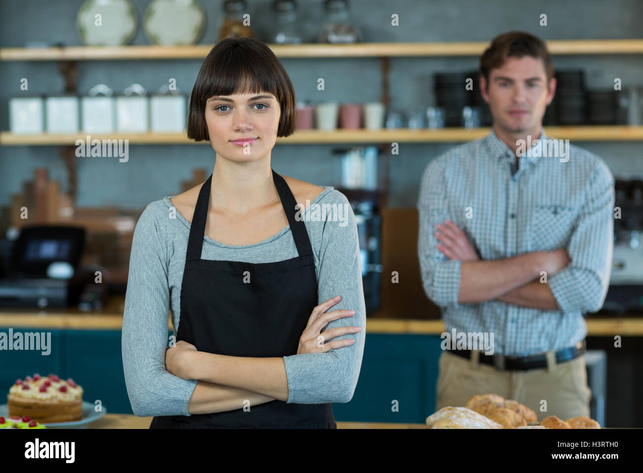 Portrait of waitress standing with arms crossed Stock Photo - Alamy
