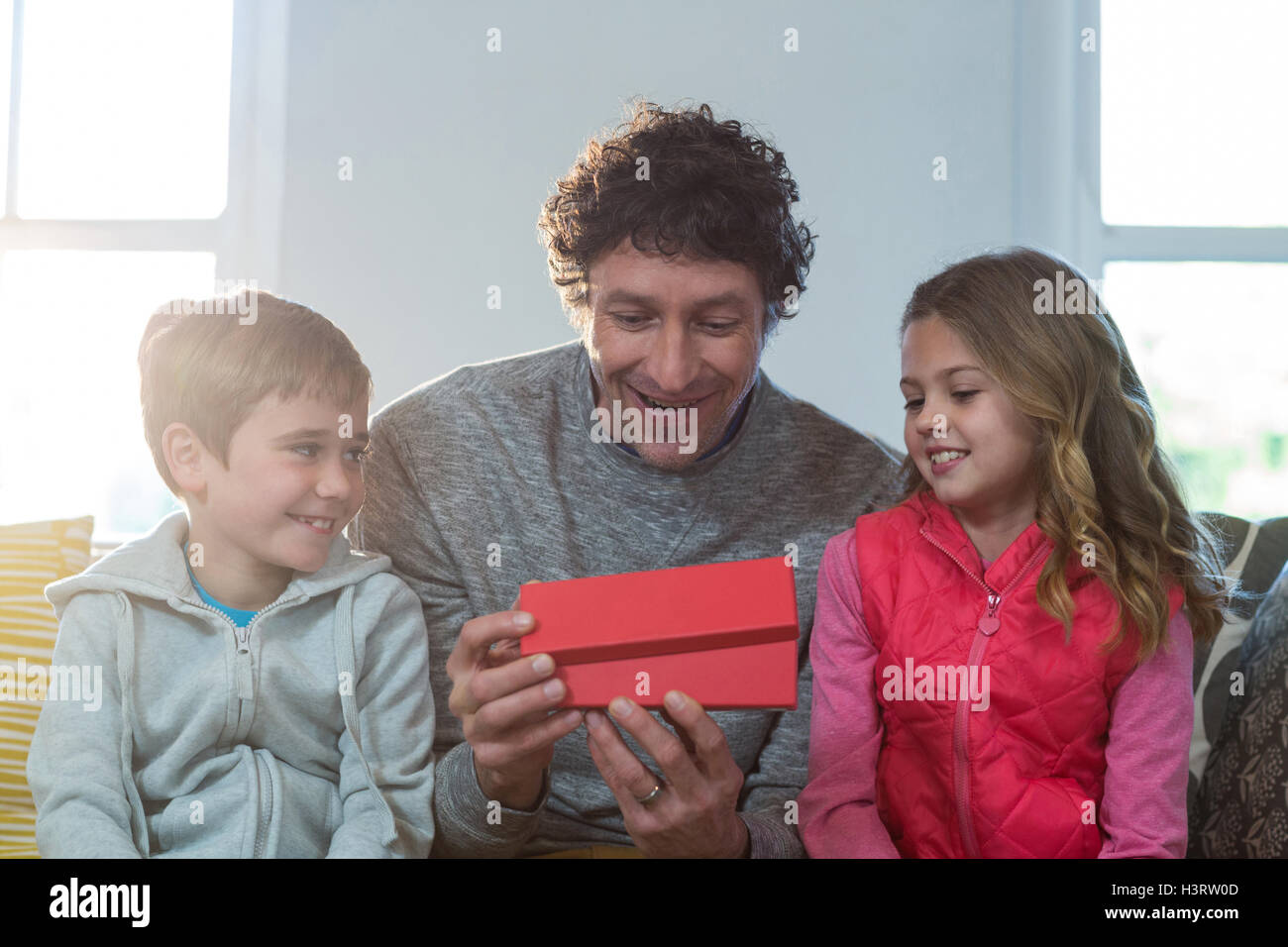 Father opening gift box with children Stock Photo - Alamy