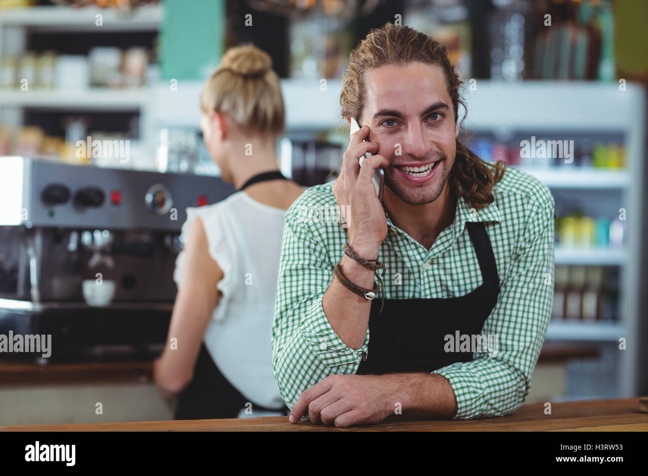 Portrait of waiter talking on mobile phone Stock Photo - Alamy