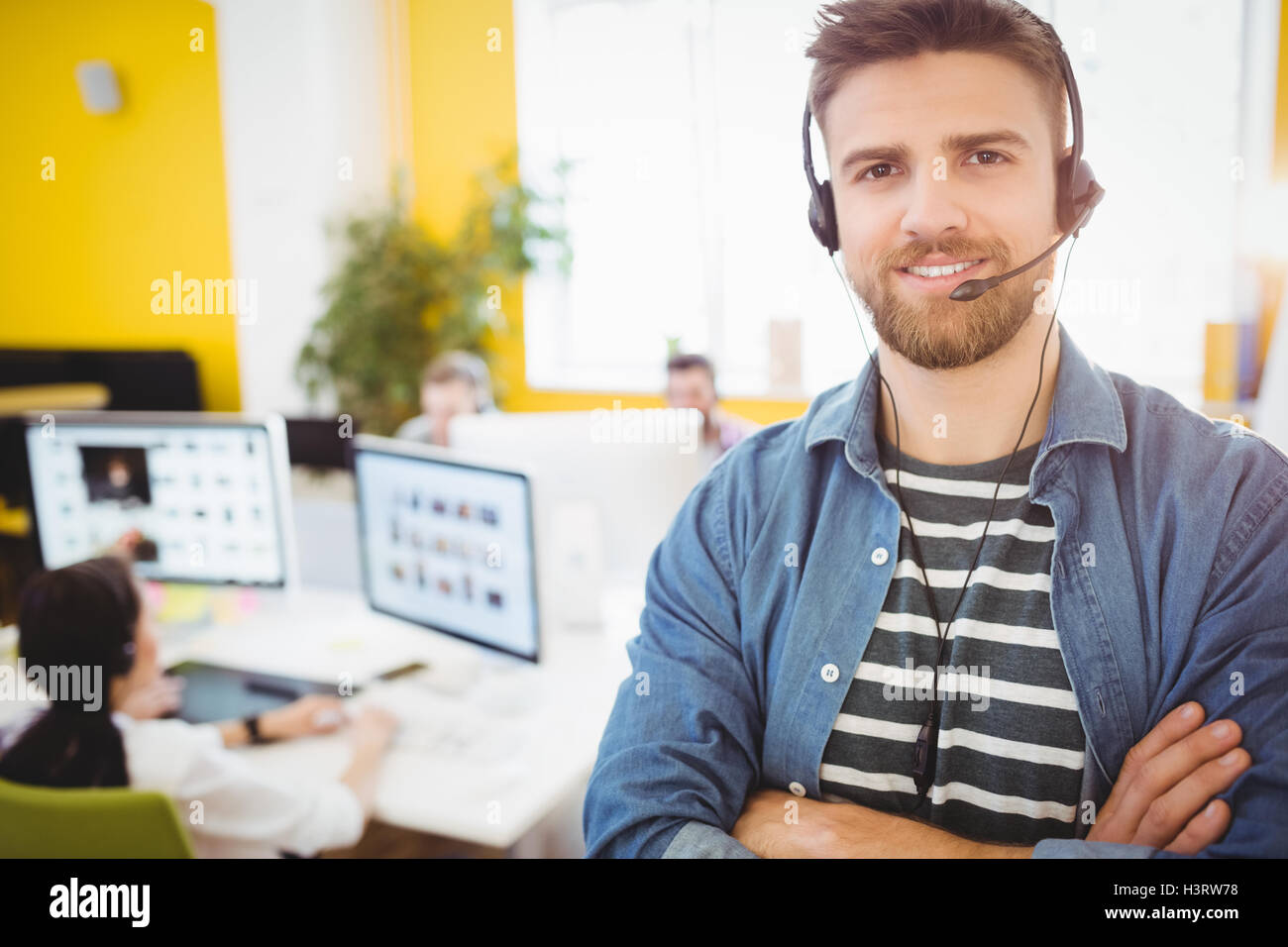 Portrait of happy executive wearing headphones at creative office Stock ...