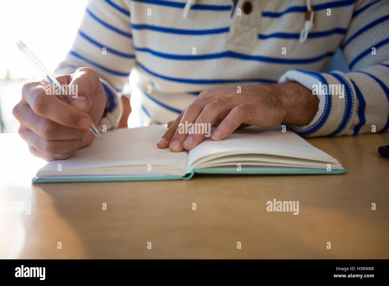 Man writing in a diary Stock Photo - Alamy