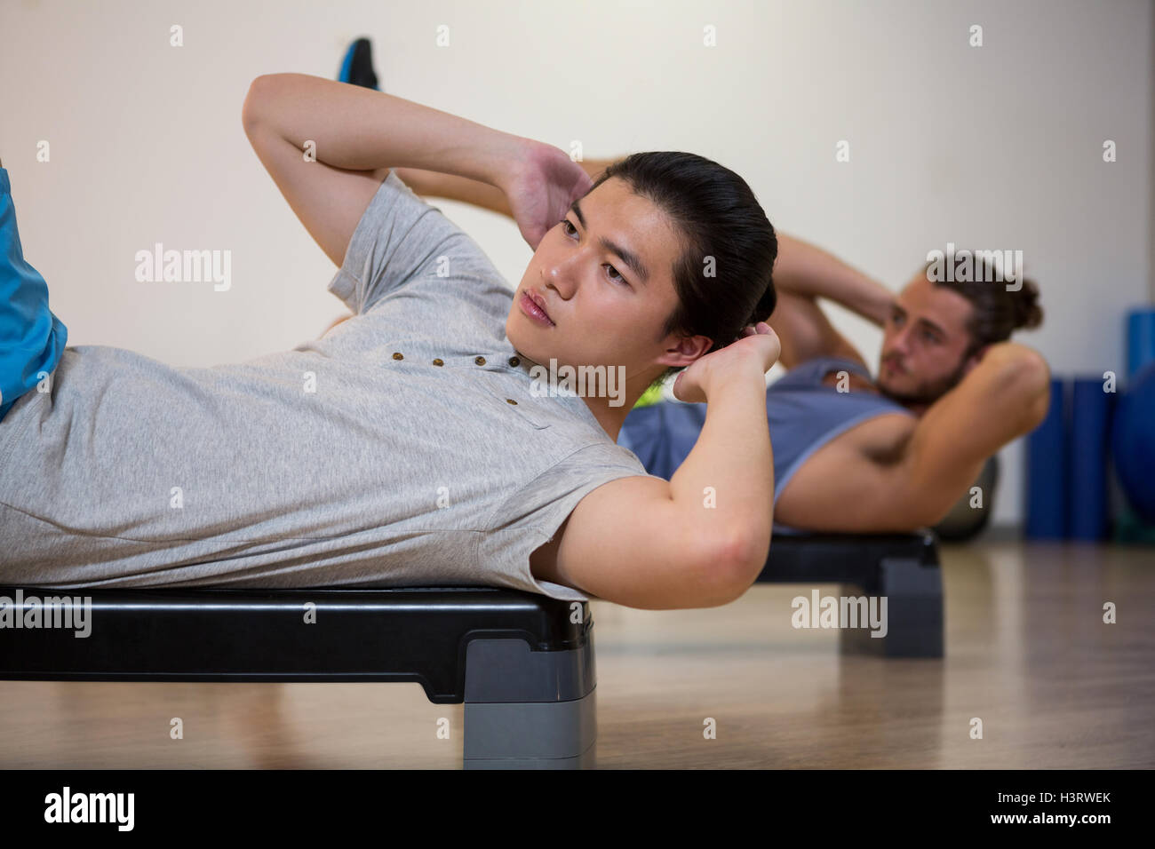 Two men doing aerobic exercise on stepper Stock Photo - Alamy
