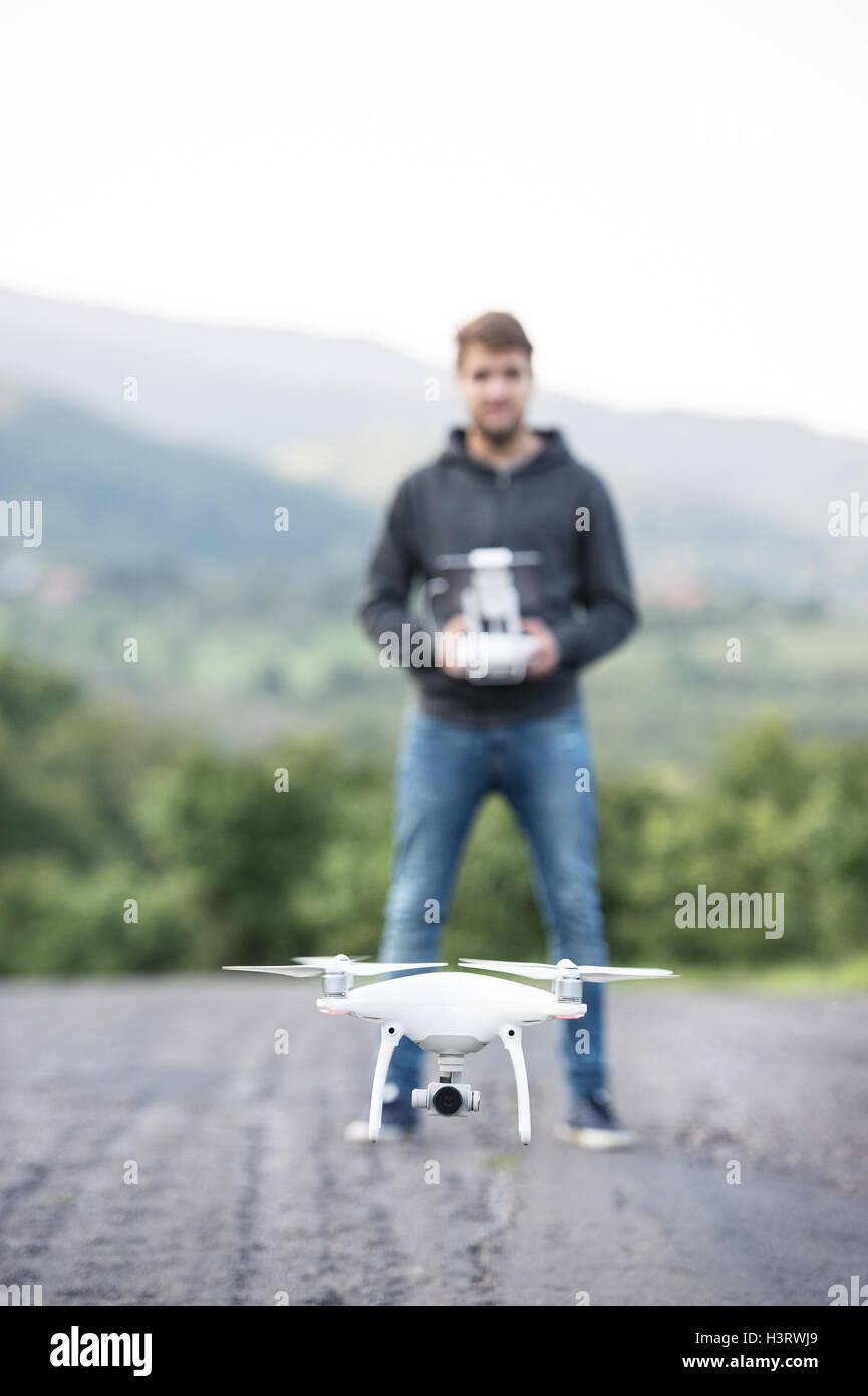 Young hipster man with flying drone. Sunny green nature Stock Photo - Alamy