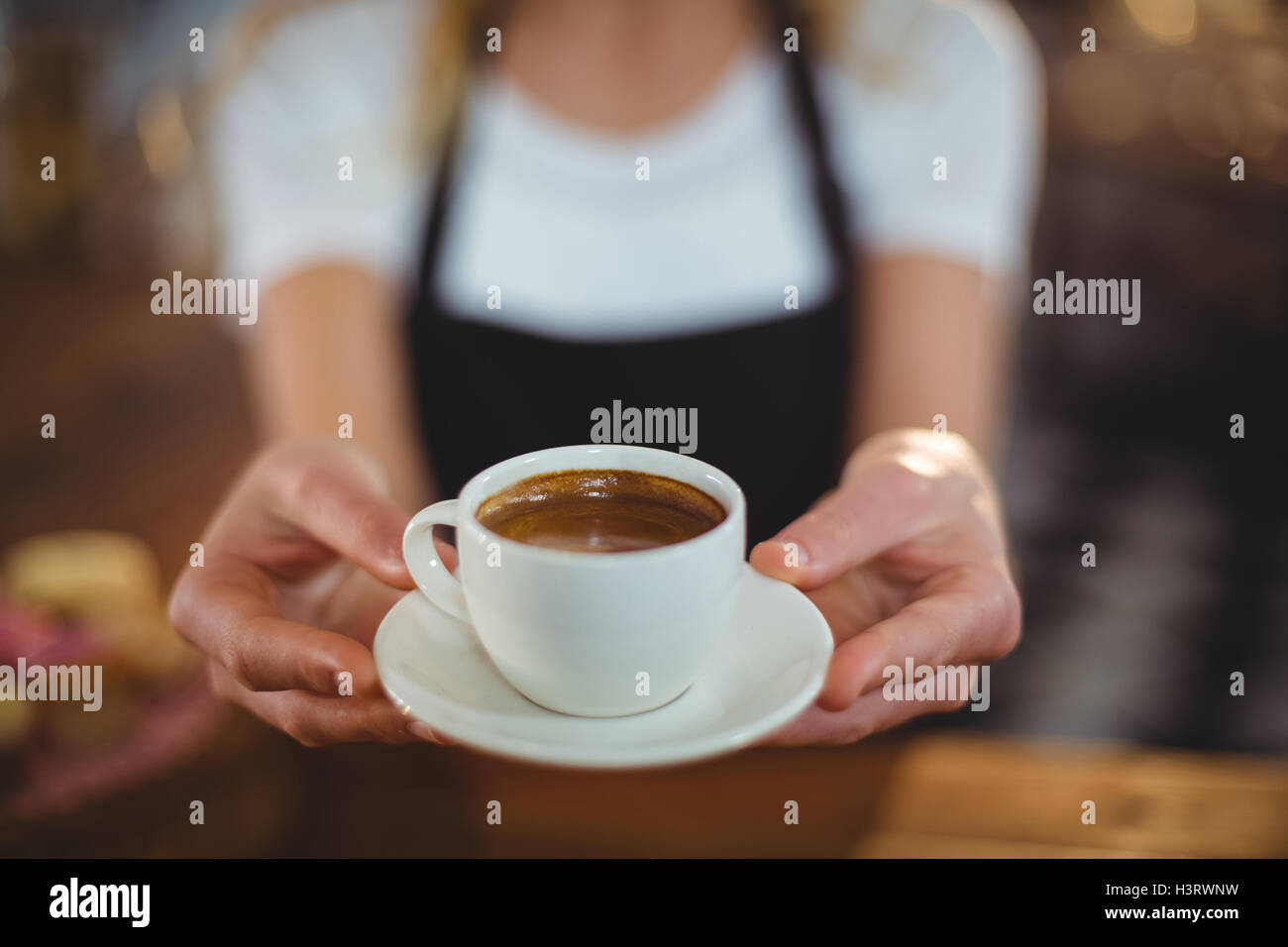 Waitress offering a cup of coffee Stock Photo - Alamy