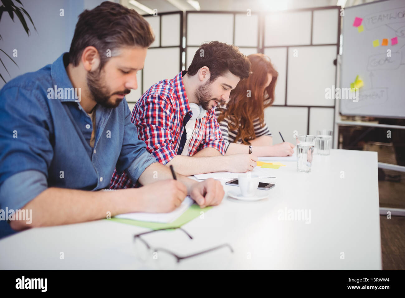 Business people writing on documents in meeting room Stock Photo - Alamy
