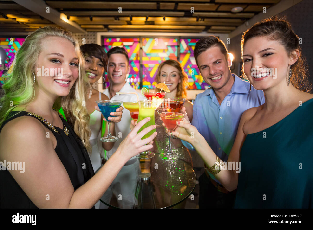 Group of friends toasting glass of cocktail in bar Stock Photo - Alamy