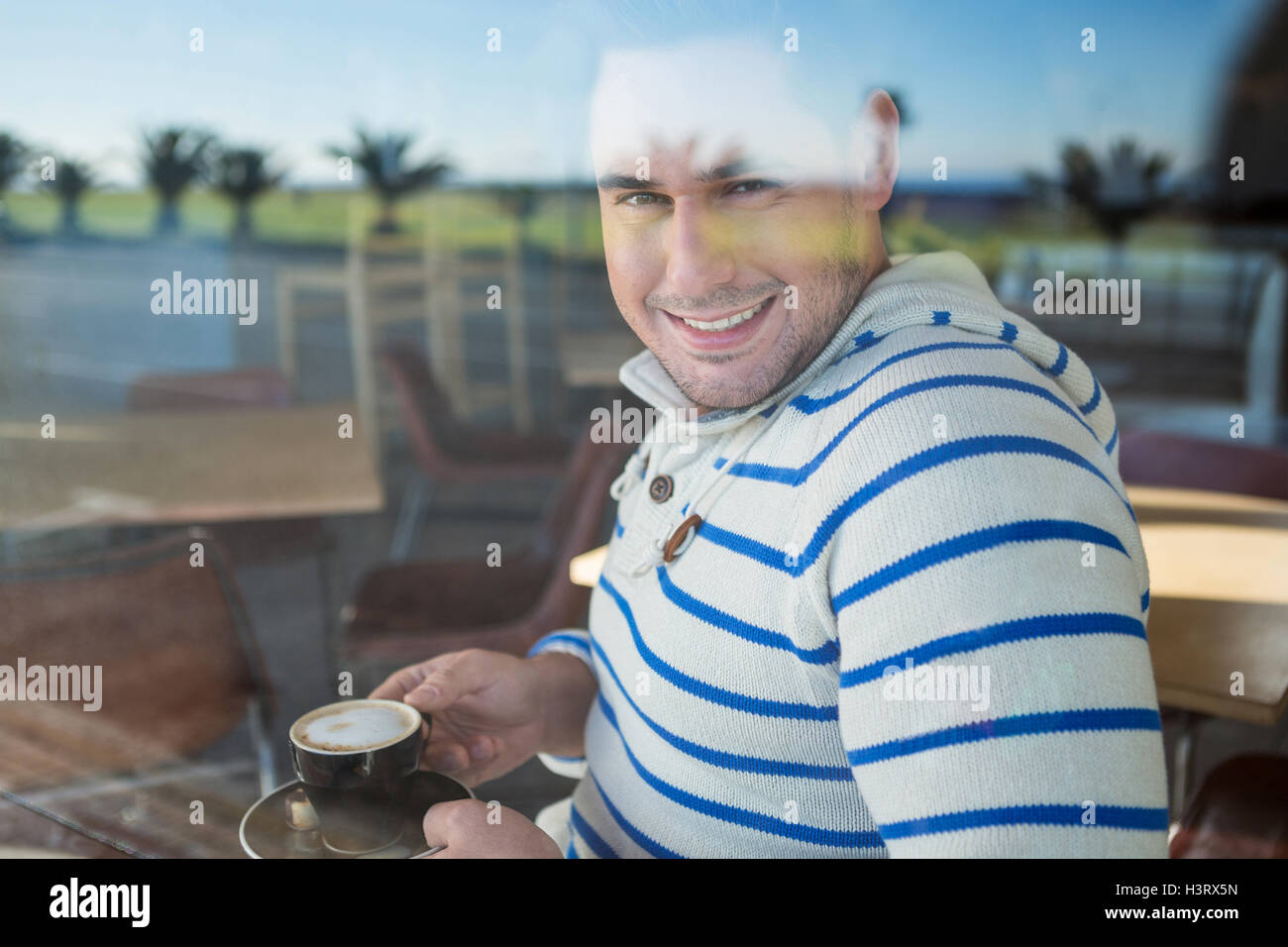 Smiling man holding a coffee cup Stock Photo - Alamy