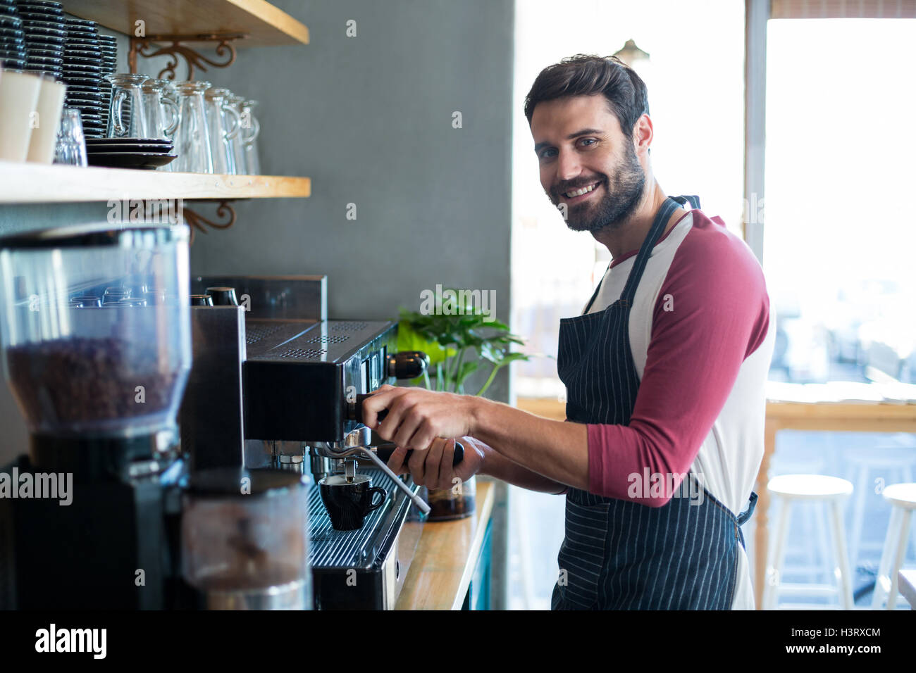 Smiling waiter making cup of coffee at counter in cafe Stock Photo - Alamy