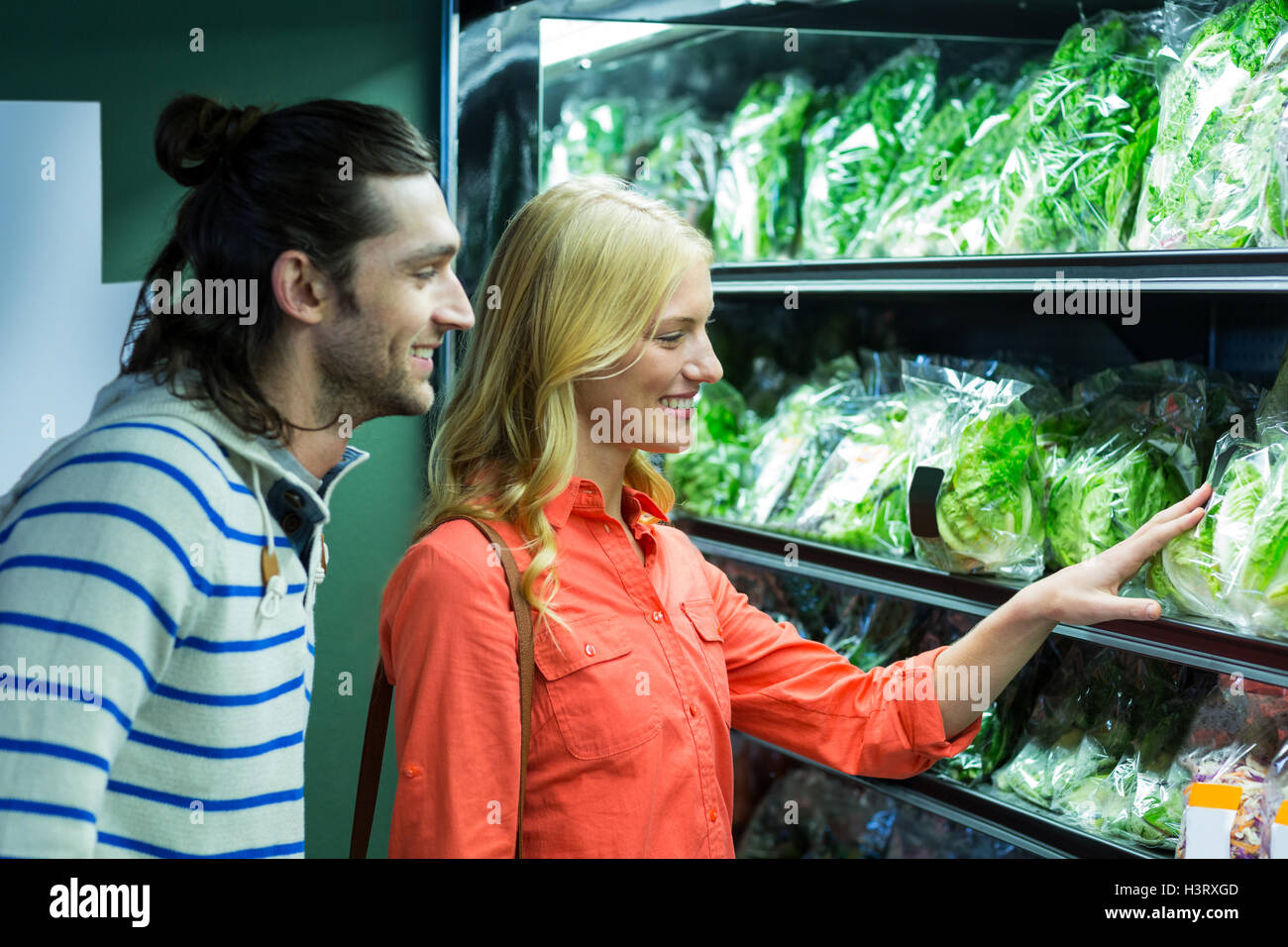 Happy couple selecting vegetables in organic section Stock Photo - Alamy