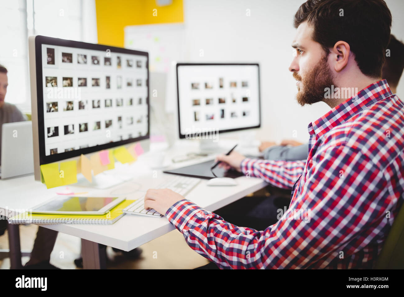 Side view of editor working on photos at creative office Stock Photo ...