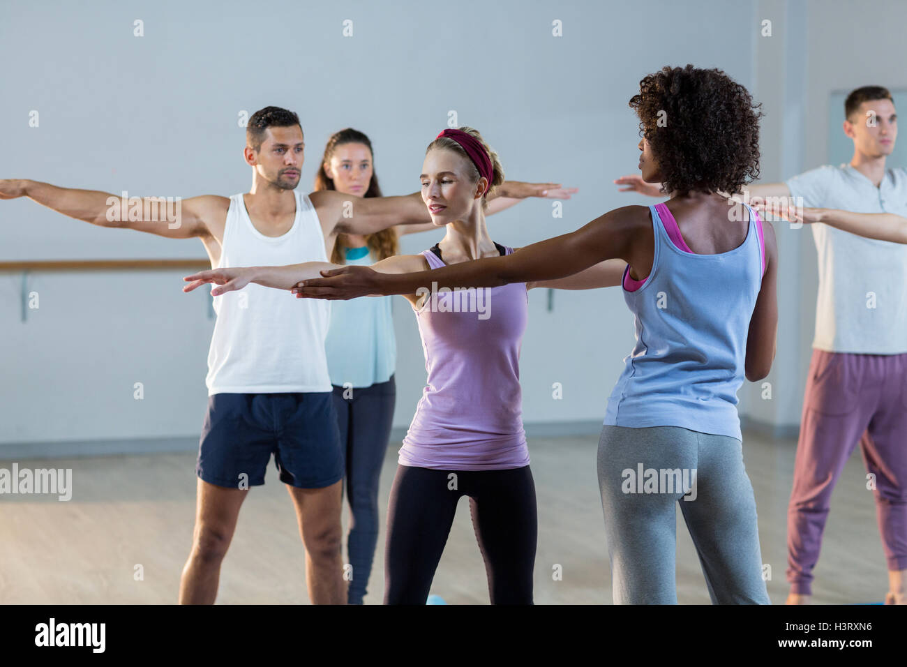 Yoga instructor helping student with a correct pose Stock Photo - Alamy