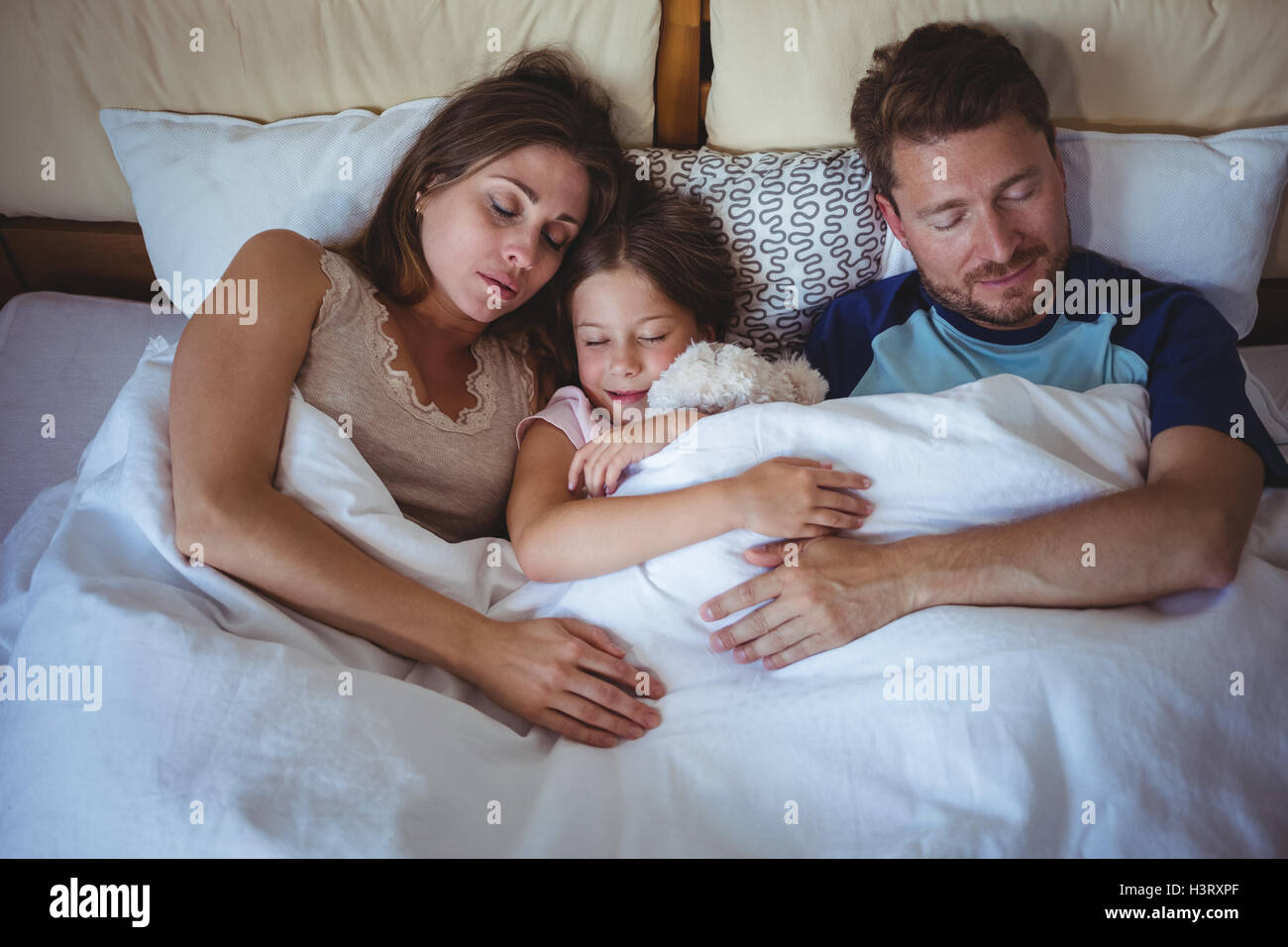 Family sleeping on bed Stock Photo - Alamy
