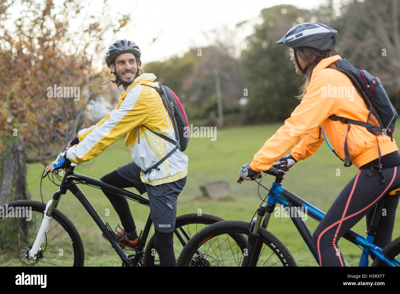 Biker couple interacting while cycling Stock Photo - Alamy