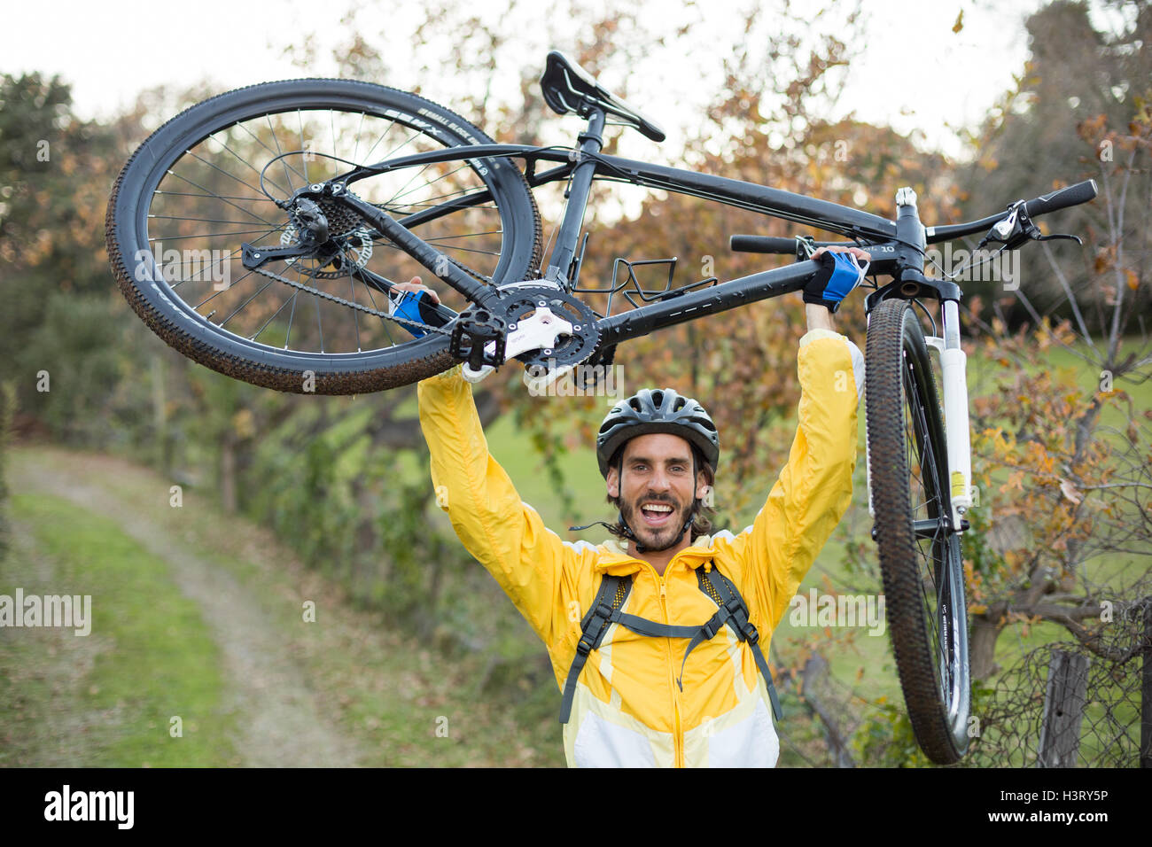 Male biker carrying mountain bike Stock Photo - Alamy