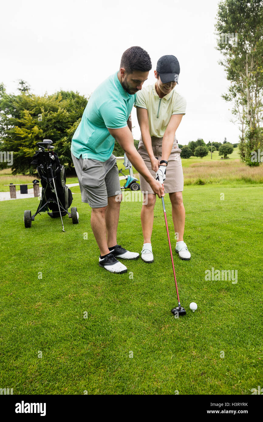 Male instructor assisting woman in learning golf Stock Photo - Alamy