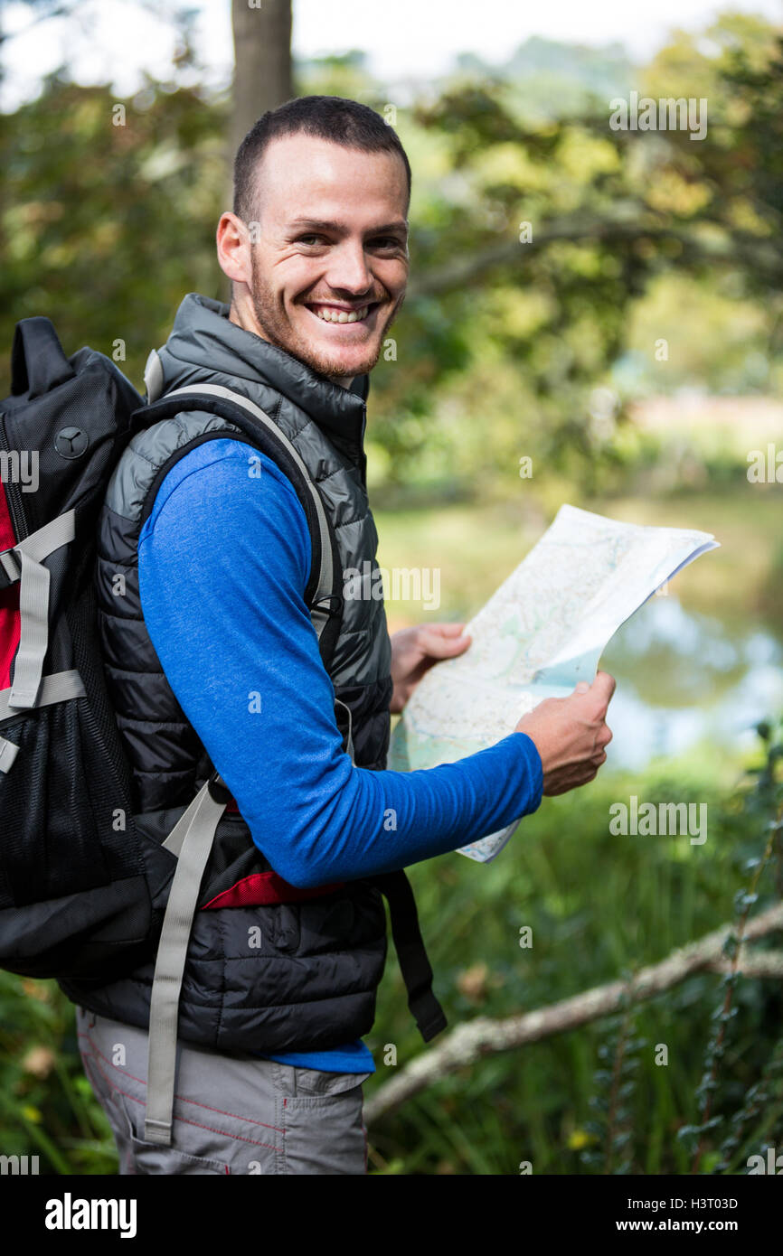 Male hiker holding a map in forest Stock Photo - Alamy