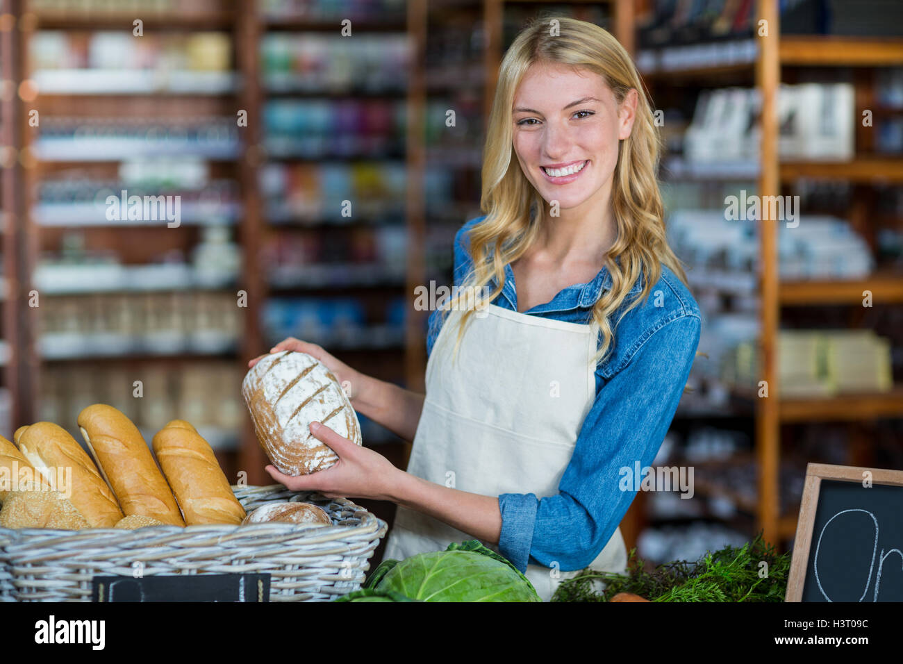 Smiling staff holding bread in organic section Stock Photo - Alamy