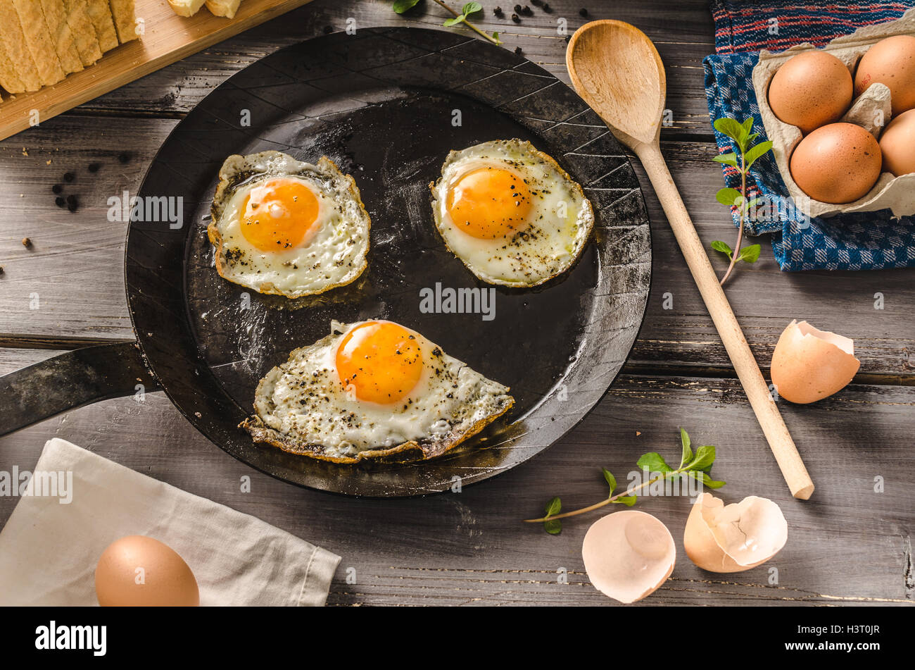 Eggs fried rustic style, bio eggs with white bread Stock Photo - Alamy