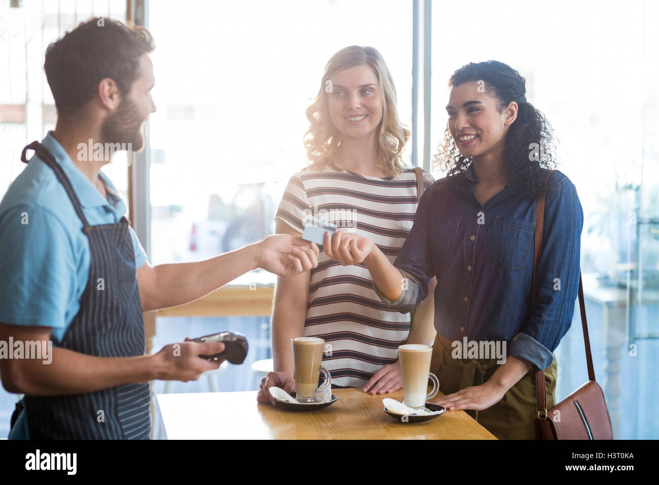 Customer making payment through payment terminal Stock Photo - Alamy