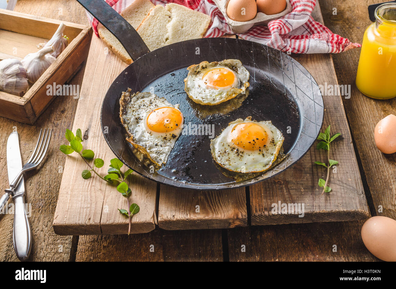 Eggs fried rustic style, bio eggs with white bread Stock Photo - Alamy