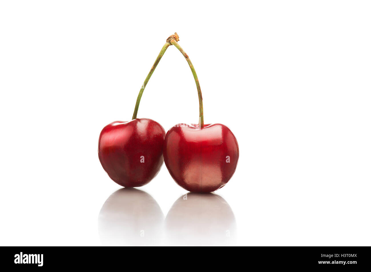 Two ripe red shiny cherries with connected stems Stock Photo - Alamy