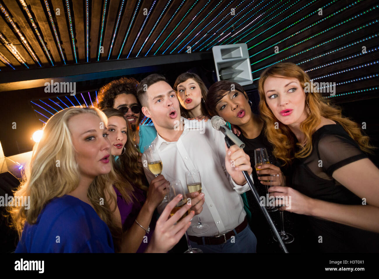 Group of friends singing song together in bar Stock Photo - Alamy