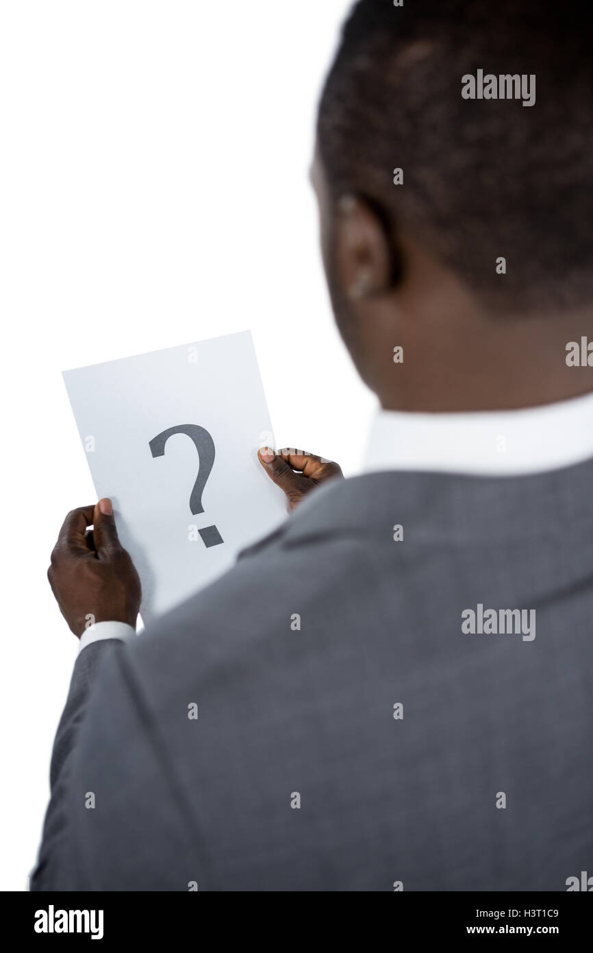Rear view of businessman holding a question mark sign Stock Photo - Alamy