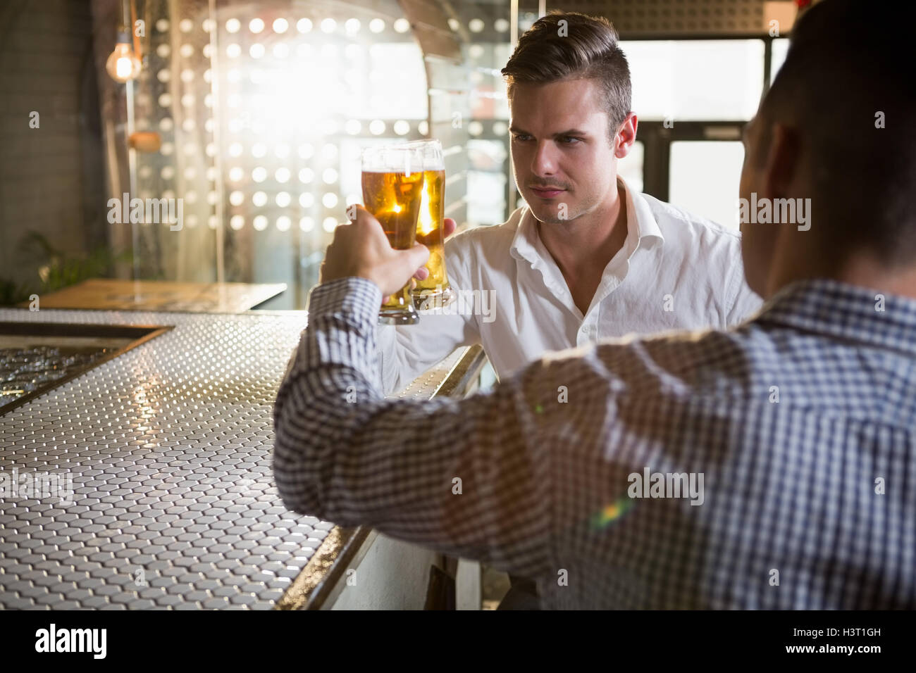Two men toasting a glass of beer Stock Photo - Alamy