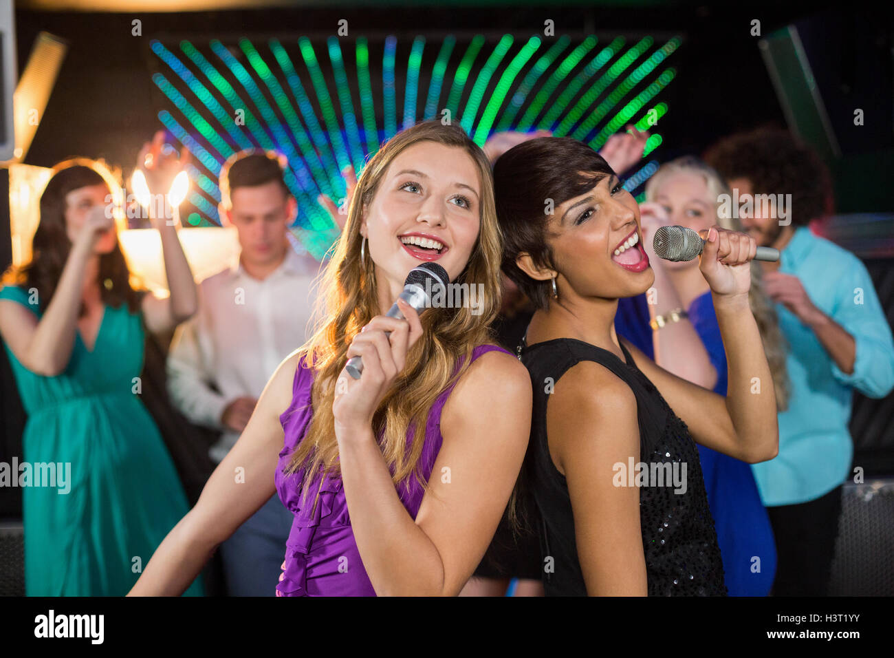 Two beautiful women singing song together Stock Photo - Alamy