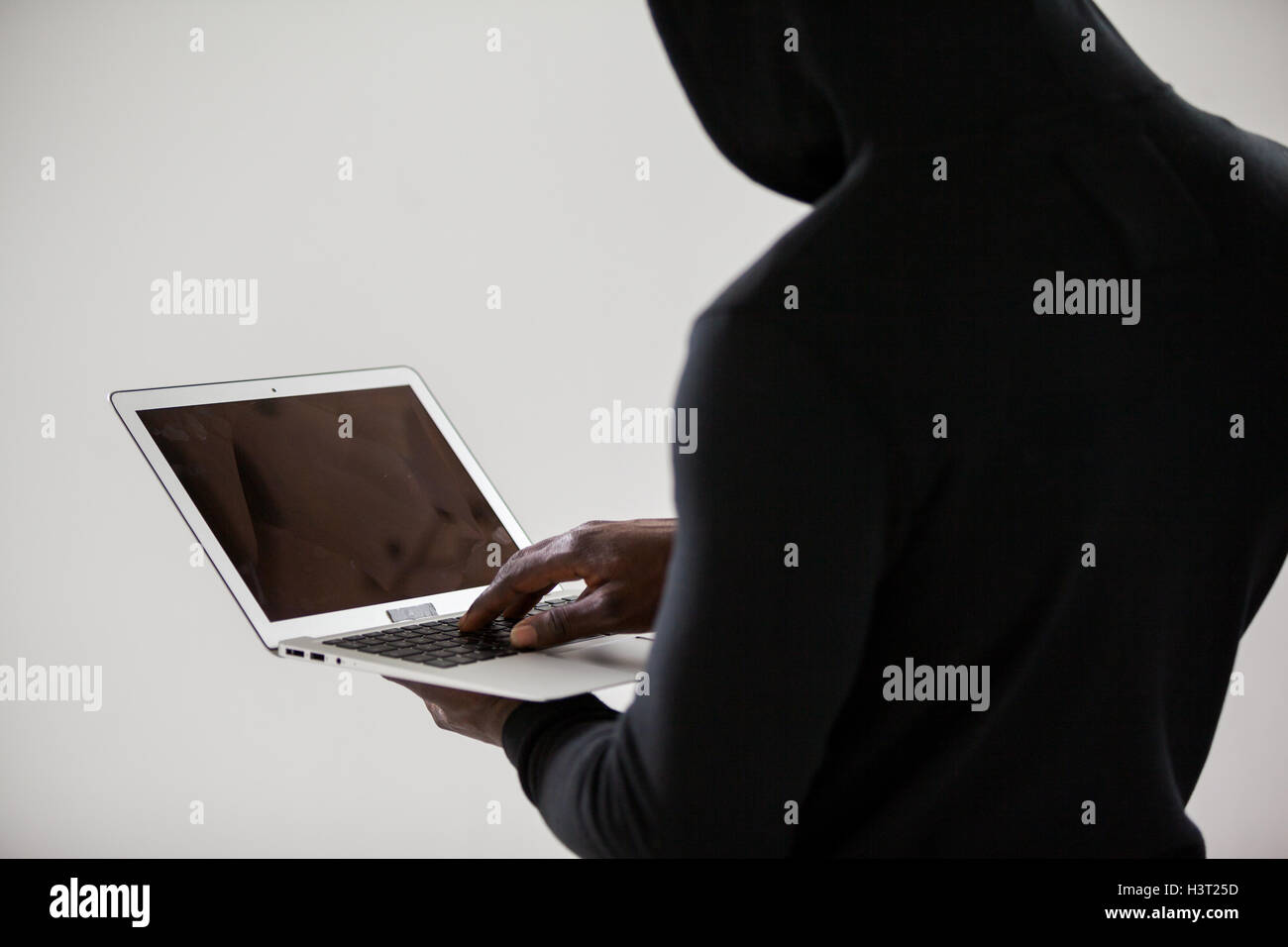 Hacker using a laptop Stock Photo - Alamy