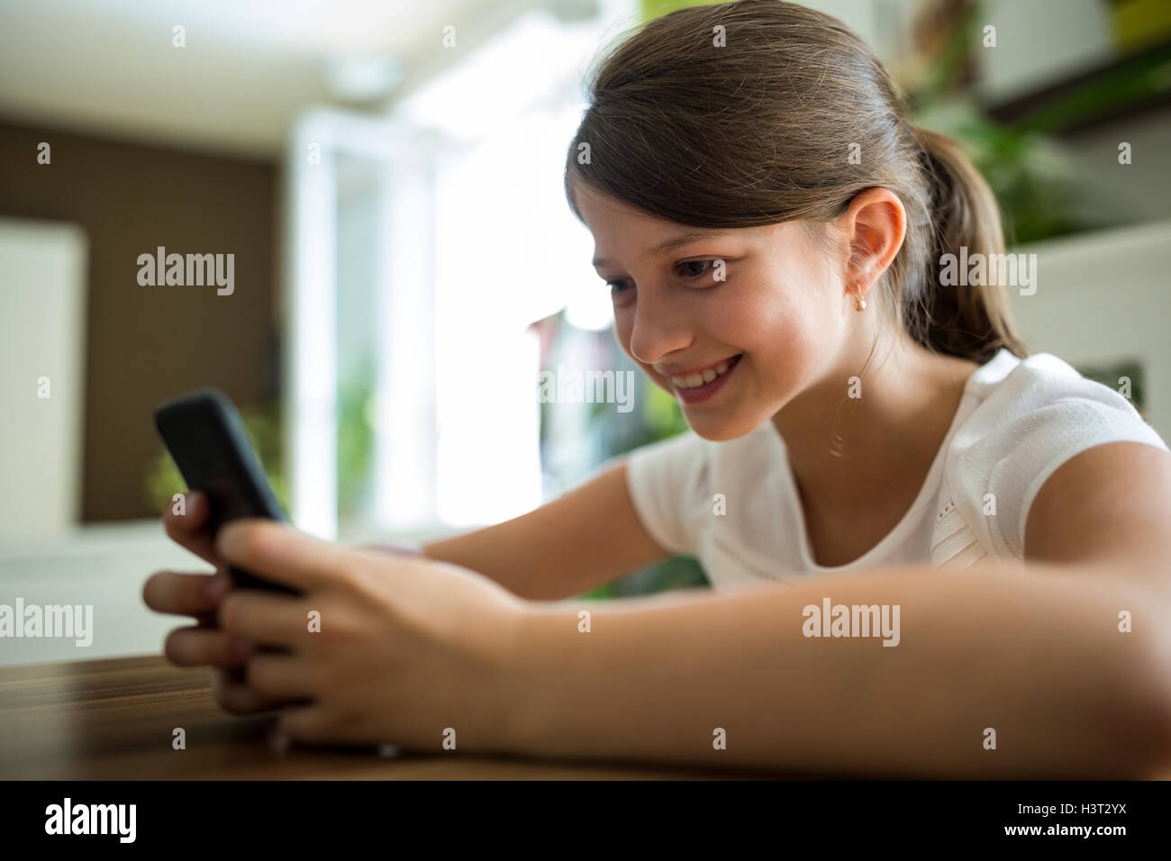 Girl using mobile phone in the living room Stock Photo - Alamy