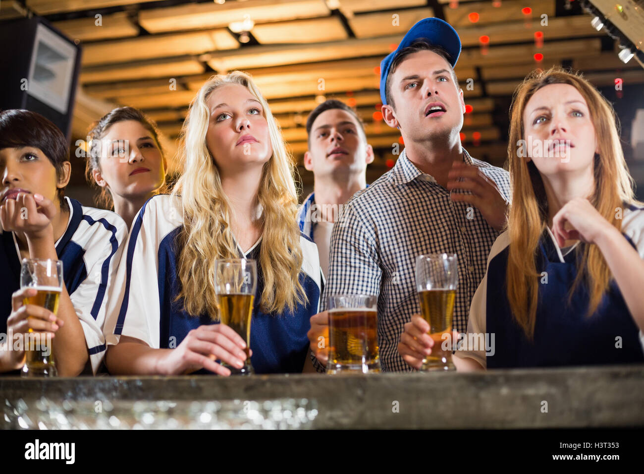 Upset fan watching football at bar counter Stock Photo - Alamy