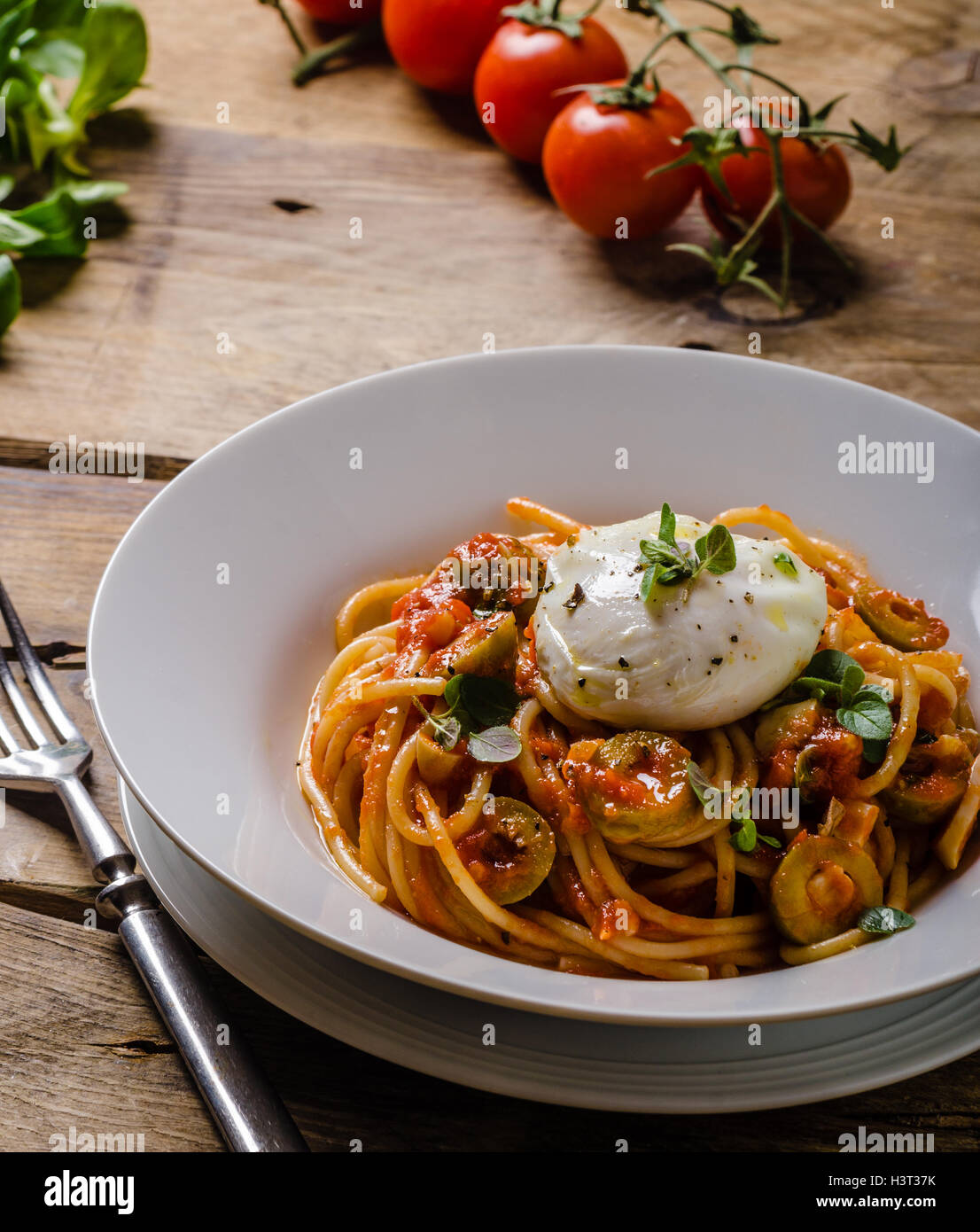 Italian tomato spicy pasta with poached egg and fresh herbs Stock Photo ...