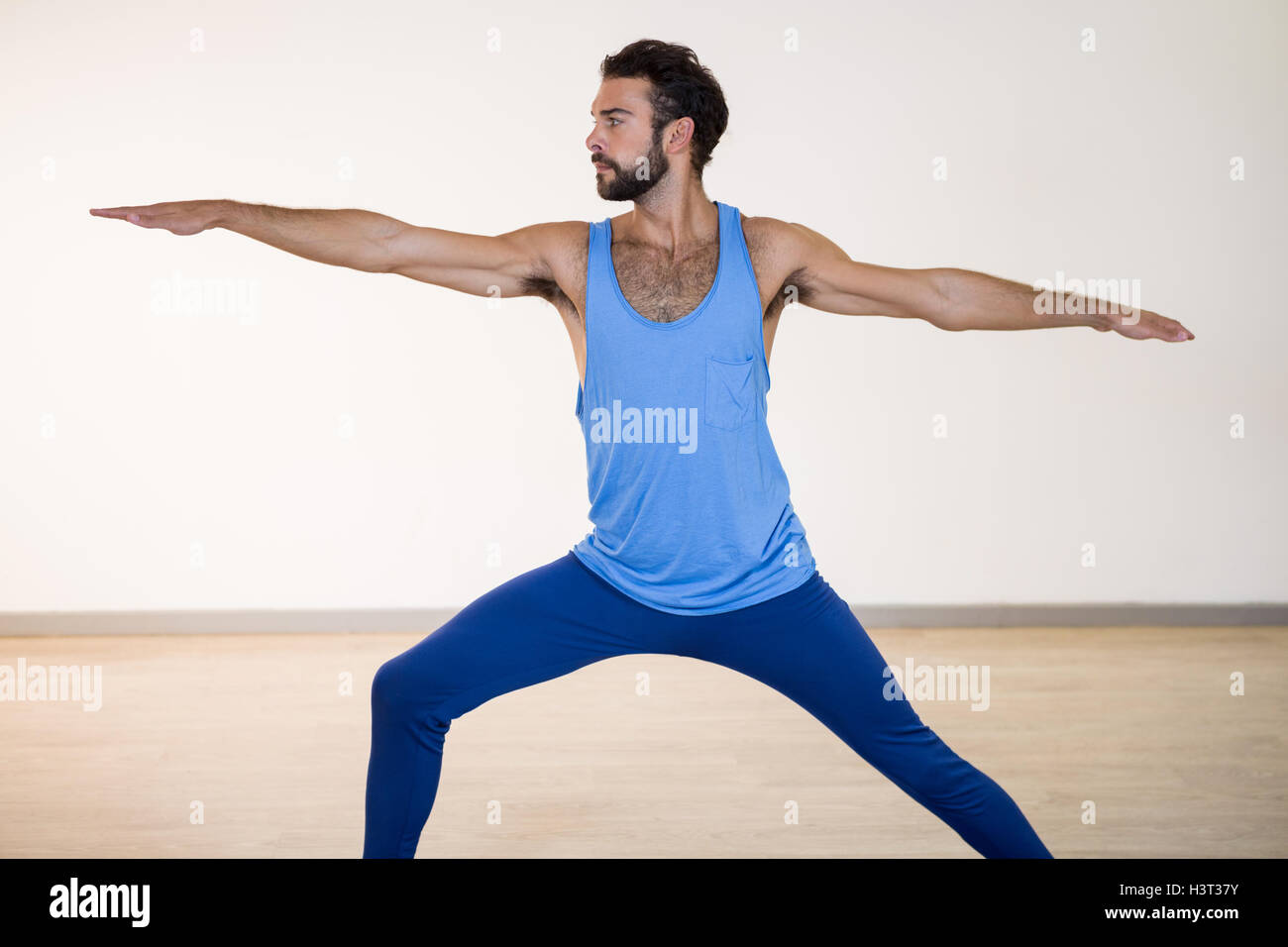 Man performing warrior pose Stock Photo - Alamy