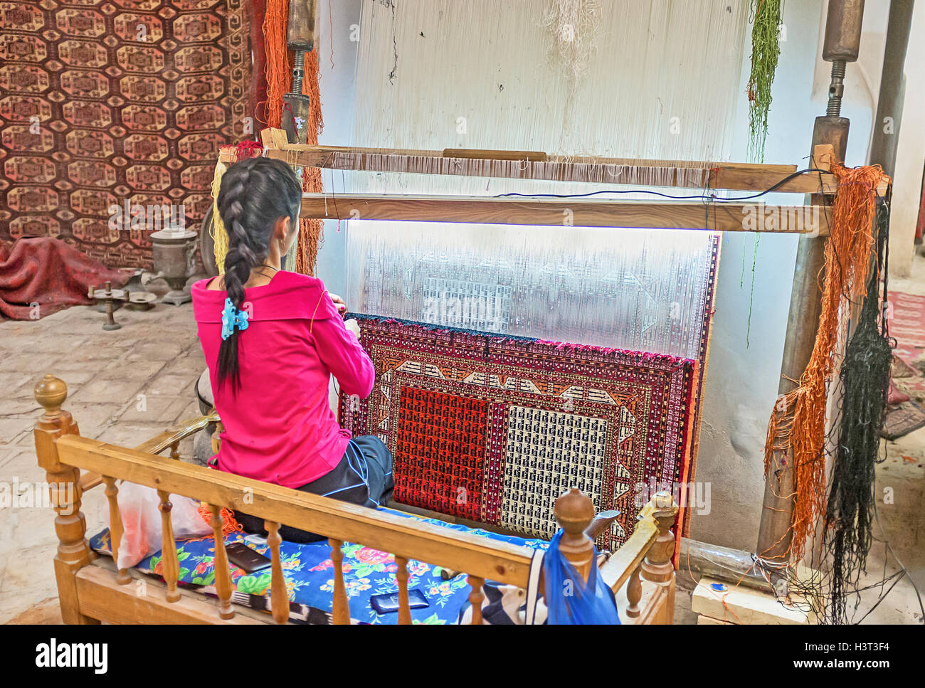 The young woman weave the traditional Uzbek rug at the workshop in ...