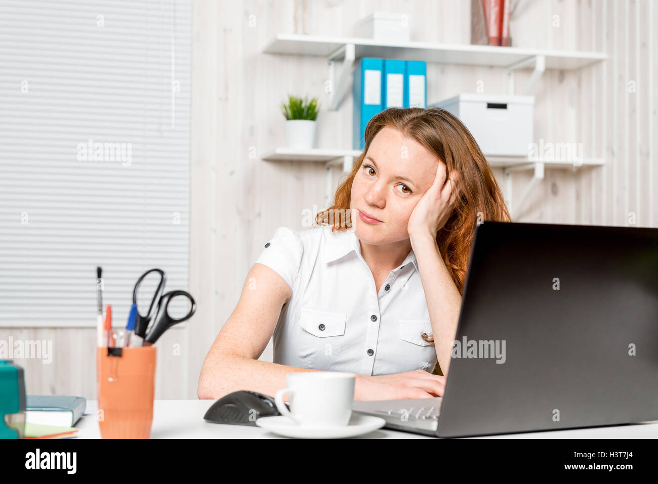 Young receptionist sitting behind a desk in the office Stock Photo - Alamy