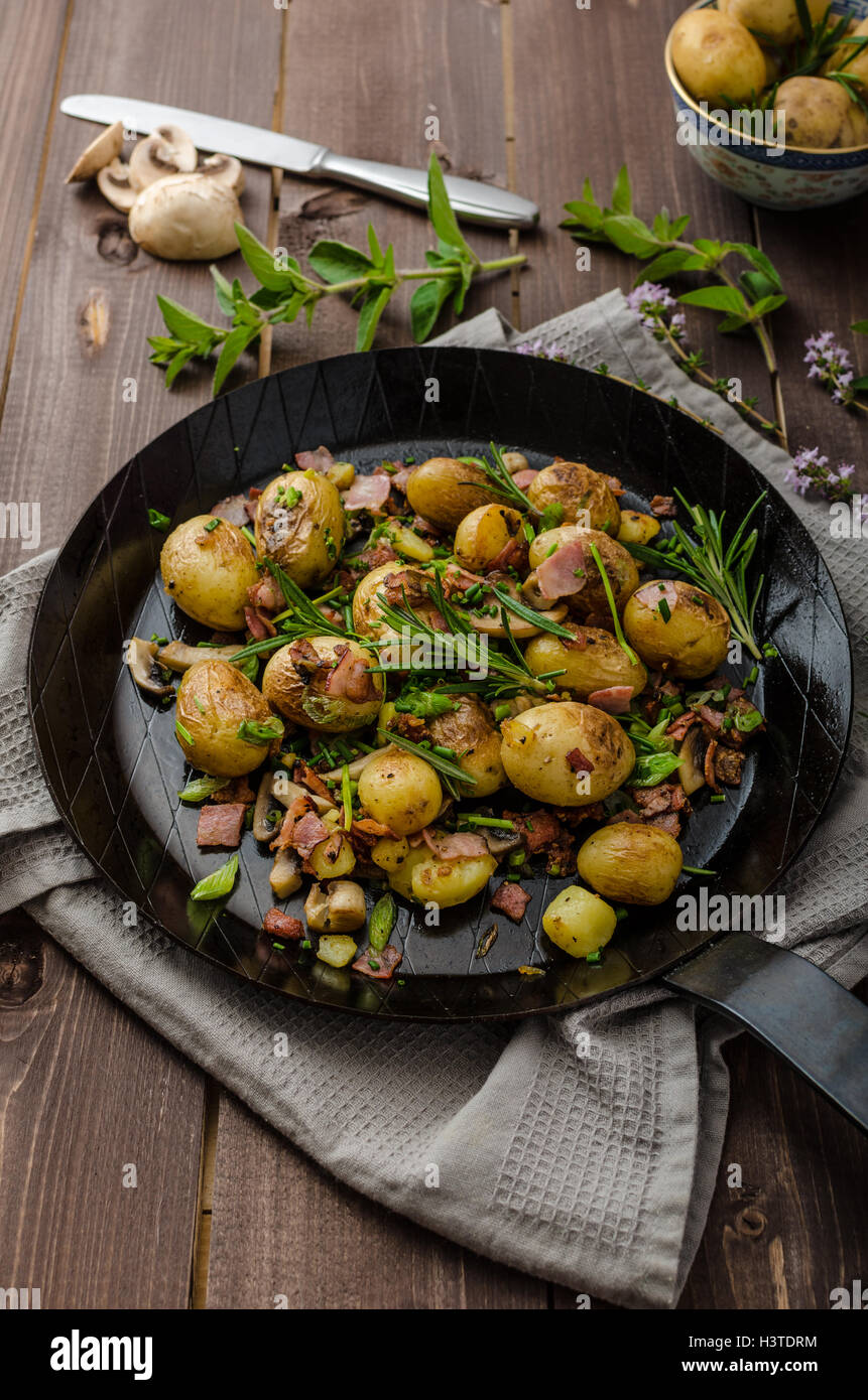 Sauteed new potatoes with bacon and herbs Stock Photo - Alamy