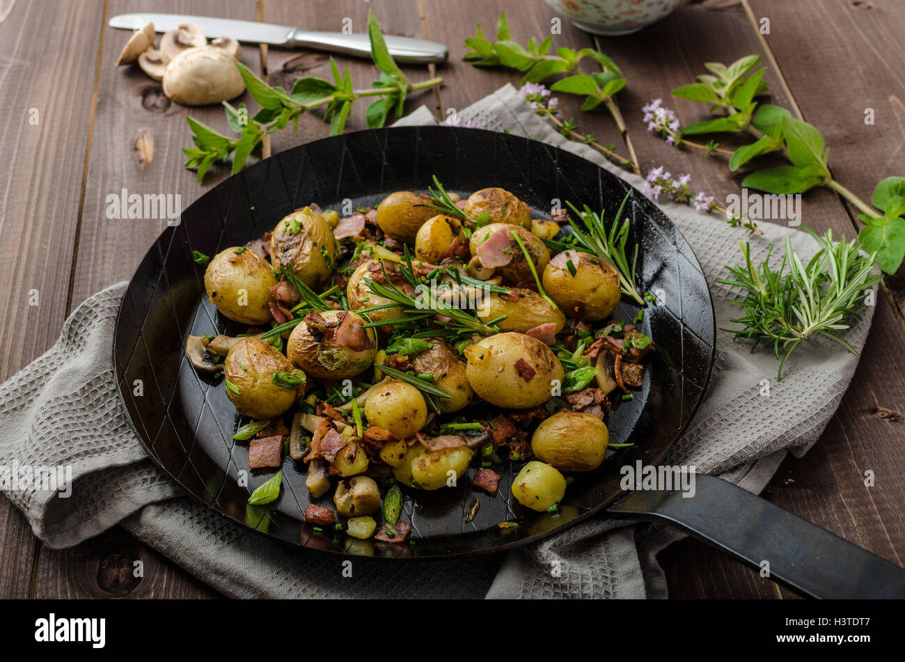 Sauteed new potatoes with bacon and herbs Stock Photo - Alamy