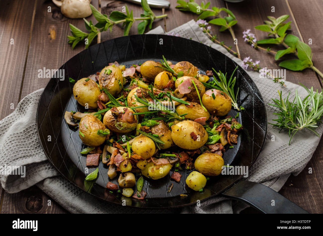 Sauteed new potatoes with bacon and herbs Stock Photo - Alamy