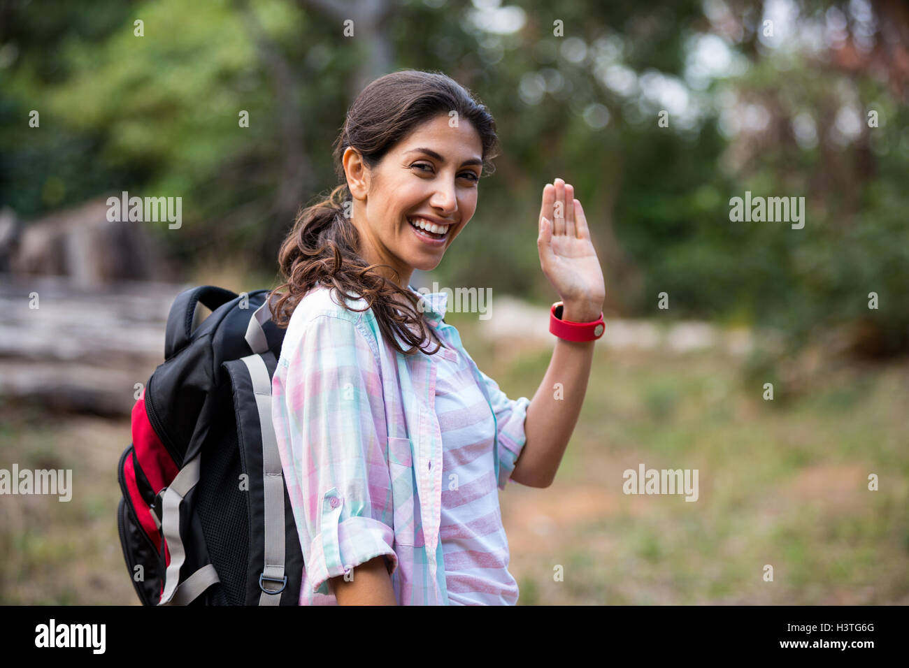 Female hiker waving hand while walking in forest Stock Photo - Alamy