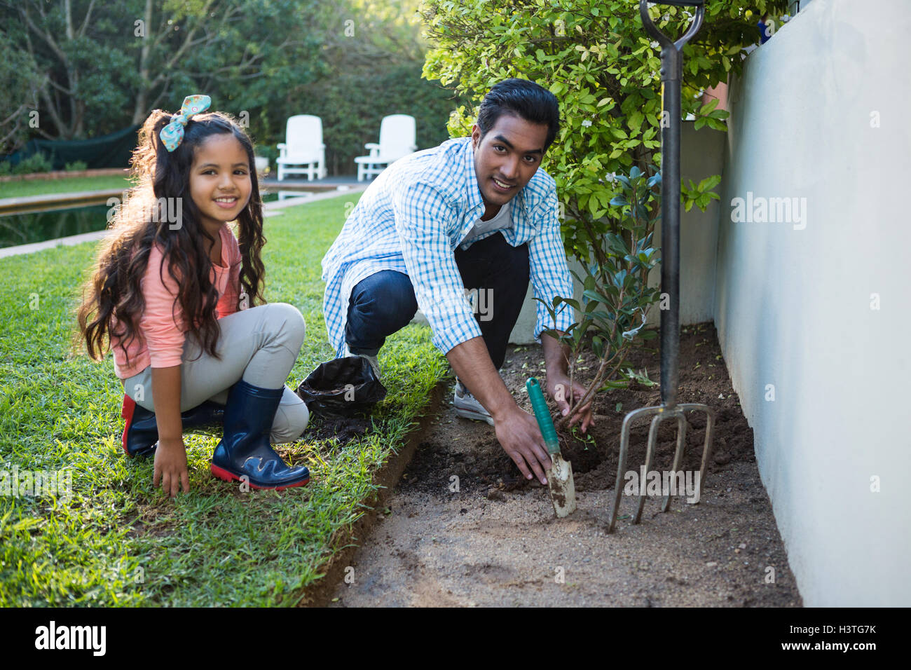 Father and daughter planting a tree in garden at backyard Stock Photo - Alamy