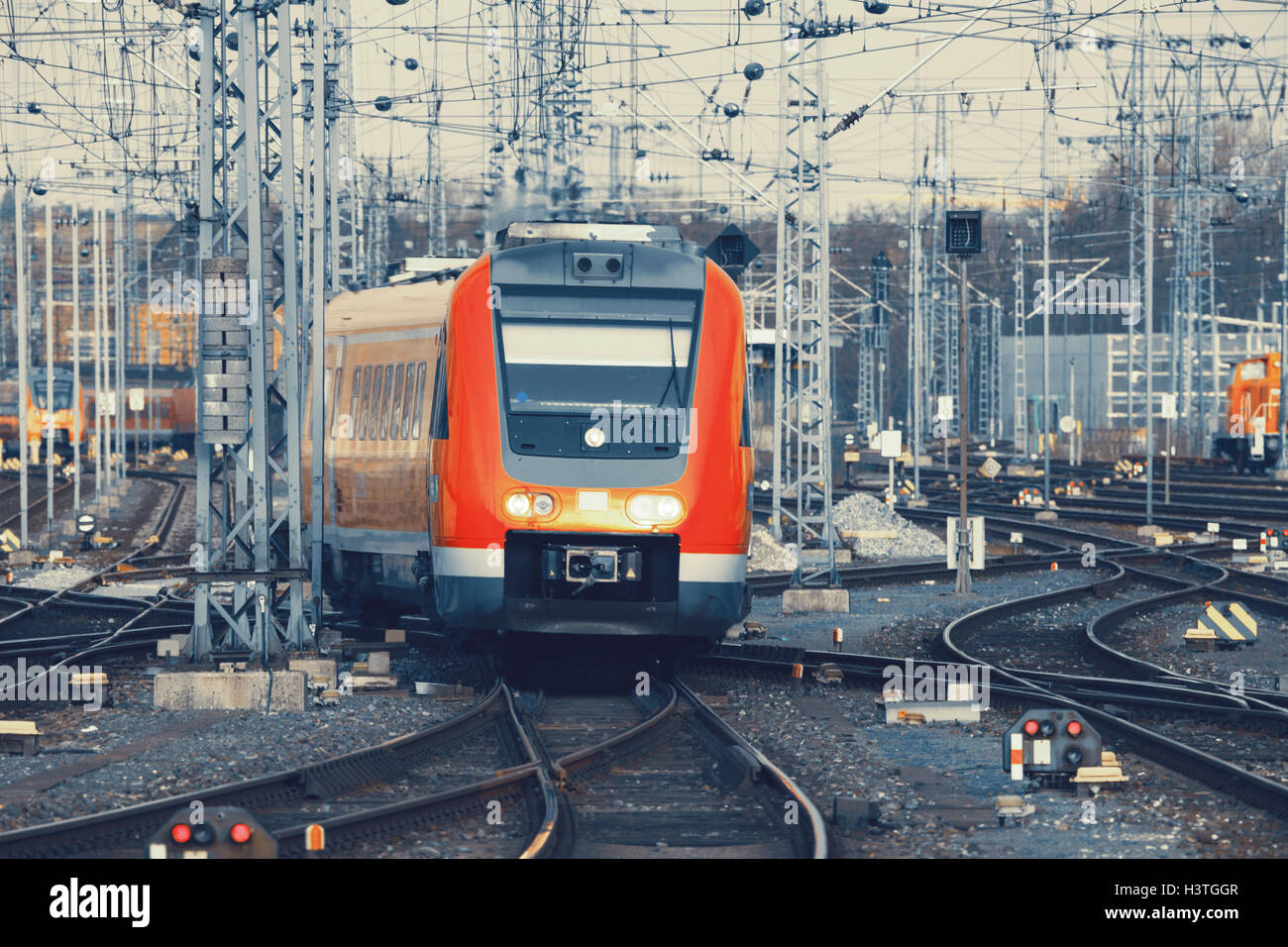 Modern orange commuter train on a railroad. Railway station in Europe ...