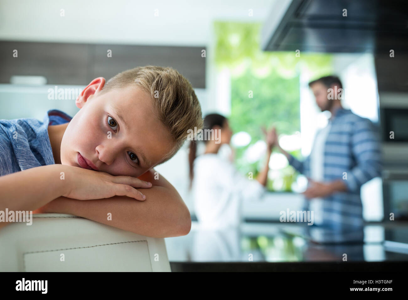 Sad boy leaning on chair hi-res stock photography and images - Alamy