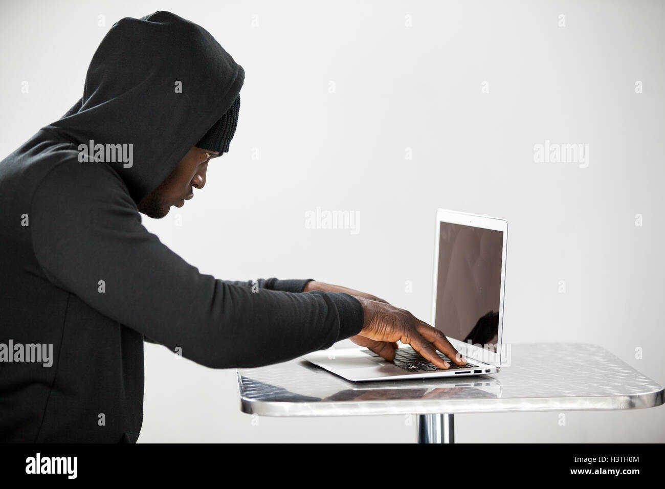 Hacker using a laptop Stock Photo - Alamy