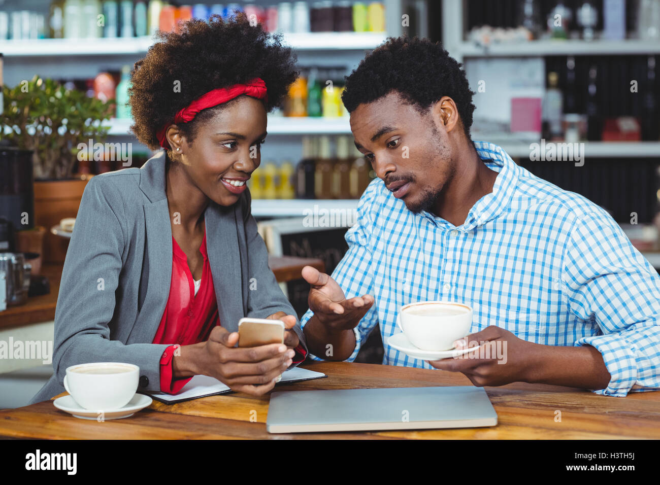 Man and woman interacting with each other while having cup of coffee Stock Photo - Alamy